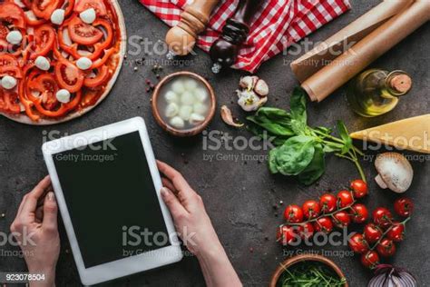 태블릿을 사용 하 여 구체적인 테이블에 피자를 준비 하는 동안 여자의 자른 음식 재료에 대한 스톡 사진 및 기타 이미지 음식 재료 탁자 태블릿 Istock