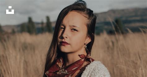 낮 동안 갈색 잔디밭에 서 있는 흰색 니트 스웨터를 입은 여자 사진 Unsplash의 무료 의복 이미지