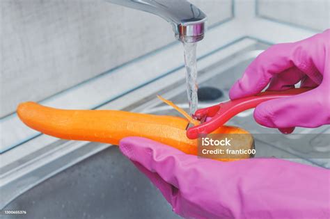야채 필러와 흐르는 물 아래 부엌 싱크대에서 당근을 청소 손은 보호 장갑을 착용하고 있습니다 가정 생활에 대한 스톡 사진 및 기타 이미지 Istock