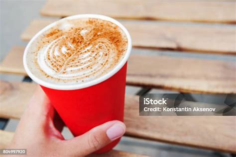 여자 커피와 빨간색 종이 컵을 들고입니다 가 서 커피입니다 화창한 날에 나무 테이블에 맛 있는 뜨거운 음료 야외 식사입니다 계피에 대한 스톡 사진 및 기타 이미지 Istock