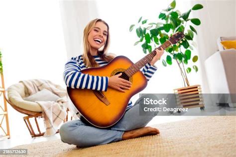 금발의 젊은 여자의 전체 크기 사진 앉아 바닥 재미 놀이 기타 옷을 입은 줄무늬 옷차림 아늑한 낮 빛 집 내부 거실 25 29세에 대한 스톡 사진 및 기타 이미지 Istock
