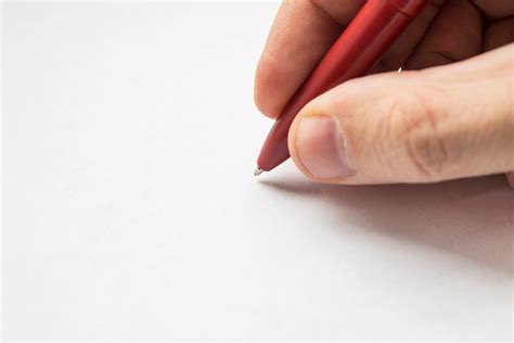 빨간 펜을 손에 들고 닫습니다 오른손에 연필을 들고 테이블에 놓인 흰색 빈 종이 위에 비어 있습니다 설계를 위한 빈 공간 개념에