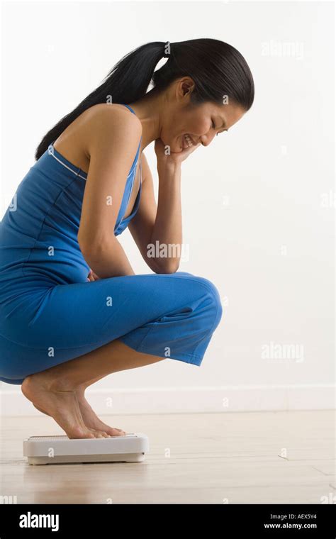 Woman Checking Weight On Scale Stock Photo Alamy