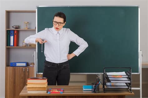 Premium Photo Young Woman Teacher Wearing Glasses Holding Pointer While Explaining Lesson