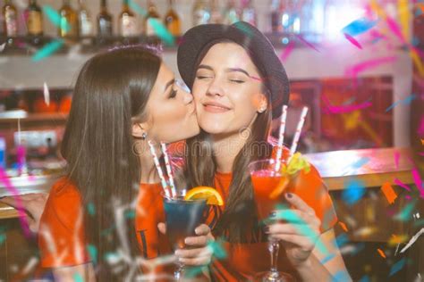 Duas Meninas Lésbicas Novas Beijo E Para Fazer Um Coração Com Suas Mãos Em Um Partido Do Clube