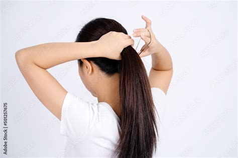 Asian Woman Tying Her Hair Up Isolated On A White Background Stock