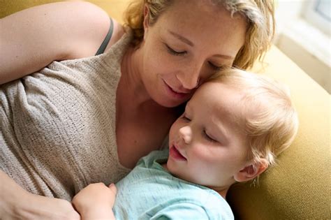 가족 자고 여자와 아들이 함께 집 거실의 소파에 누워 있습니다 아이들 위에서 집에서 잠든 엄마와 소년 아이와 함께 수면과 임신 2 3 살에 대한 스톡 사진 및 기타 이미지