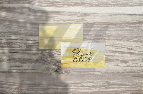 دانلود فایل لایه باز موکاپ کارت ویزیت رنگ زرد و سفید با پس زمینه چوبی دانلود رایگان فایل لایه