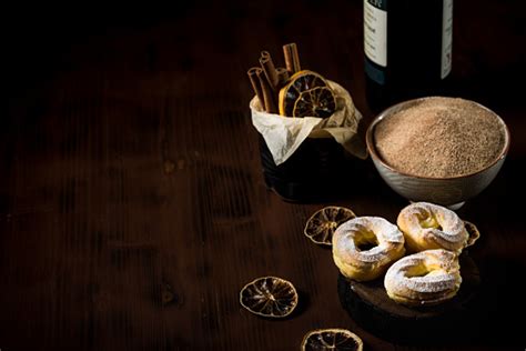 여러 수 제 퍼프 휘 핑된 크림으로 채워진 가로 사진 건조 오렌지 반지 주위 유출 그리고 빈티지에 계 피와 함께 할 수 있다 와인 병에 설탕 그릇 뒤에 있다입니다 0명에