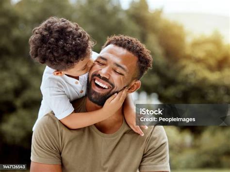 아버지 본딩 키스와 소년 아이는 야외에서 함께 좋은 시간을 보내며 자연 속에서 행복하게 포옹합니다 행복 웃음 그리고 공원에서 자연을 즐기는 아빠와 아이의 가족 사랑 아버지에