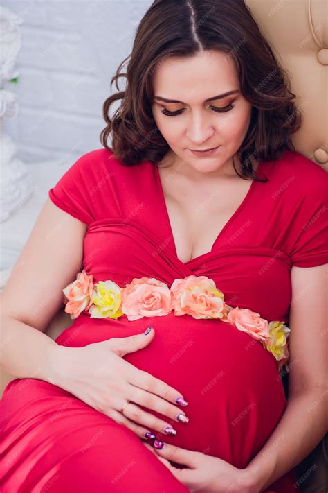 Premium Photo Pregnant Woman In A Red Dress Lying On The Sofa