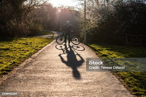 해질녘 길에 자전거와 긴 그림자를 들고 서 있는 자전거 타는 사람 30 39세에 대한 스톡 사진 및 기타 이미지 30 39세 35 39세 건강한 생활방식 Istock
