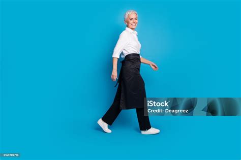 연금 수령자 숙녀 산책 프로필 서브 고객 커피 숍 옷을 입은 웨이트리스 유니폼 파란색 배경에 고립 된 전체 길이 사진 걷기에