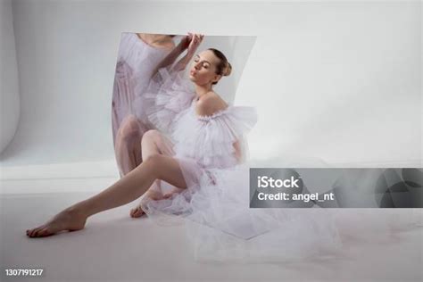 밝은 투명 드레스를 입은 로맨틱한 미녀 여성이 바닥에 앉아 있는 유연한 거울에 반영되어 있습니다 완벽한 몸과 긴 다리 20 24