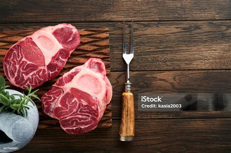 오소 부코 생 스테이크 고기 바베큐 고기 원시 신선한 크로스 컷 송아지 정강이와 조미료 후추 로즈마리 백리향 및 오래된 나무 배경에 소금 골수로 쇠고기 다리 슬라이스