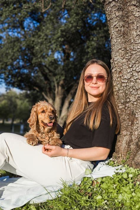 Cocker Spaniel And Owner Share A Moment Of Love Under A Tree In The