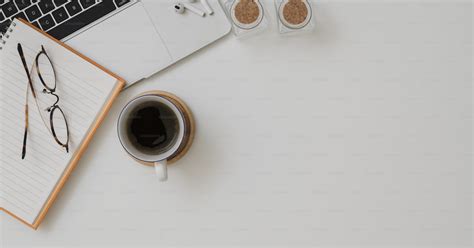 노트북 컴퓨터 커피 한 잔 흰색 책상 배경에 사무용품이 있는 최소한의 작업 공간의 상위 뷰 사진 Unsplash의 인간의 손 이미지