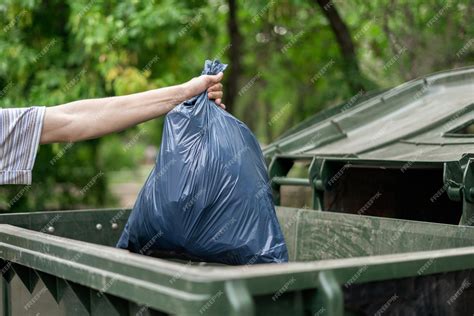 Premium Photo Male Dumping Waste Package Into A Big Trash Bin Containers