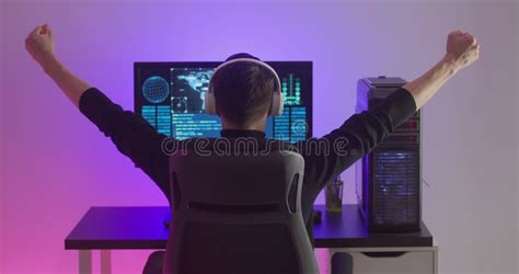 man programmer in headphones happy with success while working at a
