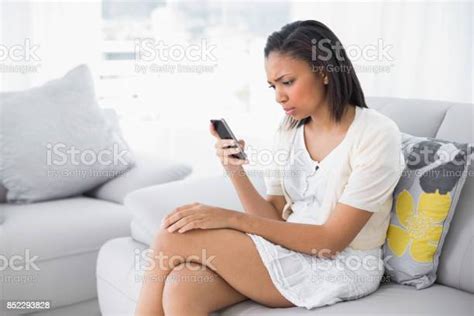 휴대 전화를 사용 하 여 흰 옷에 의아해 젊은 어두운 머리 여자 18 19세에 대한 스톡 사진 및 기타 이미지 18 19세 가정 생활 거실 Istock