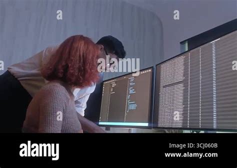 Two Developer Or Programmer Colleagues Collaborating On Programming And Data Analysis Using