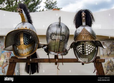 3 Ancient Roman Gladiator Helmets On A Stand In Front Of A Tent Stock