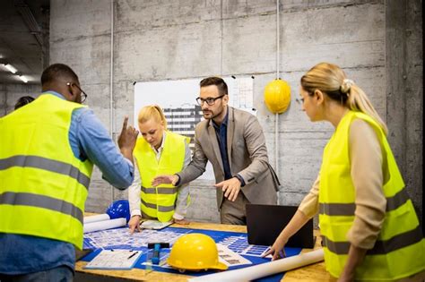 Premium Photo Contractor And Architects Analyzing Building Plan And Blueprint Together At