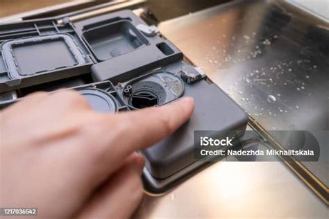 식기 세척기의 플라스틱 세제 및 컨디셔너 디스펜서에 표시된 손가락 식기 세척기의 열린 용기 수납칸 닫기 가사 집안일에 대한 스톡