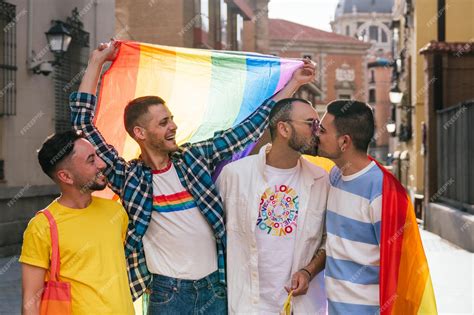 Closeup Of Four Gay Friends Embracing Two Sharing A Blissful Kiss