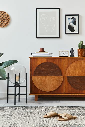 세련된 나무 Commode 모의 포스터 프레임 램프 책 선인장 장식 카펫과 복고풍 홈 장식스칸디나비아 거실의 인테리어 디자인