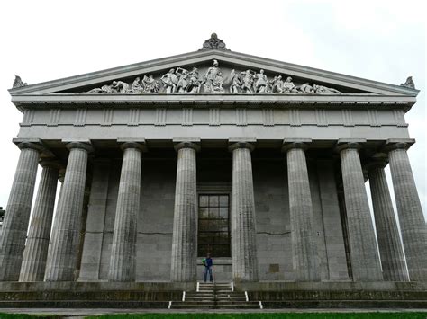Input Imposing Enormous Building A Person Standing In Front Of A Large