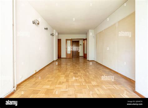 Empty Room With Oak Parquet Flooring White Painted Walls And Dark