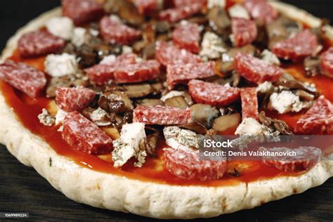 피자 요리 Chiken 살라미 소시지 두꺼운 반죽 피자 크 러스트 피자의 고기는 어두운 테이블 조리 과정 버섯 샴 피 뇽 닭고기와 소시지 살라미 소시지와 피자에 닭고기에
