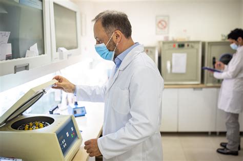 혈액 분석기 기계에 혈액 샘플을 넣어 보호 얼굴 마스크를 가진 실험실 과학자 2명에 대한 스톡 사진 및 기타 이미지 2명