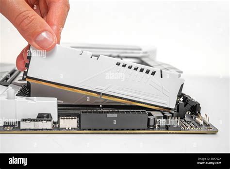 A Person Is Carefully Inserting A White DDR RAM Module Into A Motherboard Slot Stock Photo Alamy