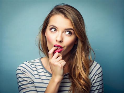 A Young Women Making A Curious Face With Her Tongue Out And Hand On Her
