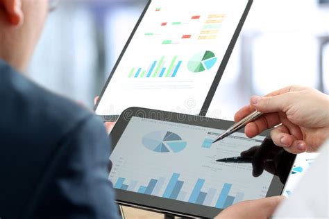 Business Colleagues Working Together And Analyzing Financial Figures On A Graphs Stock Image