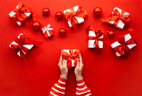 메리 크리스마스와 해피 홀리데이 인사말 카드 새해 빨간 배경에 크리스마스 선물을 들고 젊은 여자의 손 겨울에 대한 스톡 사진 및