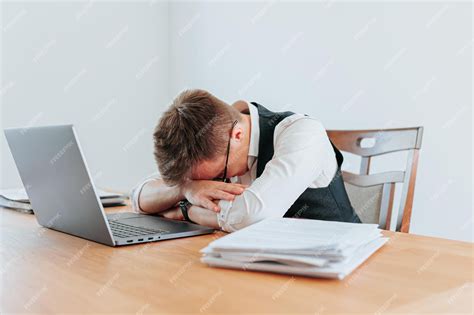 Premium Photo A Tired Office Worker Takes A Nap At His Desk Exhausted From A Long Day Of