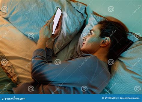 Top View Adult Woman Using Smartphone In Bed At Night Scrolling Social