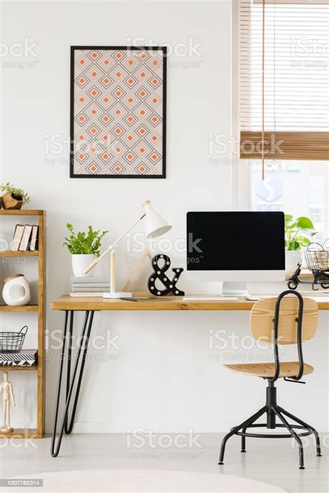 작업 영역 내부에서 램프 및 데스크톱 컴퓨터와 나무 책상 위에 흰색 벽에 포스터 실제 사진 가구에 대한 스톡 사진 및 기타