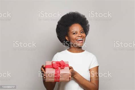 빨간 선물 상자를 들고 흰색 스튜디오 배경에서 즐거운 시간을 보내는 젊은 쾌활한 여자 선물에 대한 스톡 사진 및 기타 이미지 선물 손 쥠 Istock