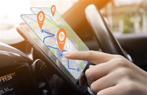 자동차 안에서 스마트폰으로 Gps 내비게이션 앱을 사용하는 사람 화면에 음식 위치 핀이 표시됩니다 여행 음식 배달의 기술 개념에 이상적 Brand Name Smart