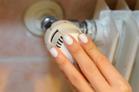 Hand Regulating The Thermostatic Valve For Setting The Temperature Of