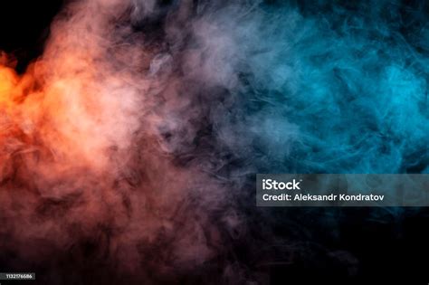 검은 고립 된 땅에 주황색 보라색 빨간색과 파란색 물결 모양의 연기의 배경입니다 부드럽게 클럽을 상승의 Vape에서 증기의 추상적인 패턴입니다 티셔츠를 위한 모 캡과 프린트