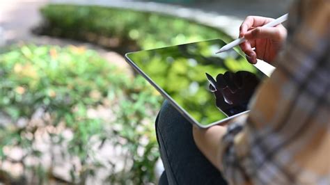 Premium Photo A Female Noting Her Project Ideas On Her Tablet Touchpad While Relaxing In The Park