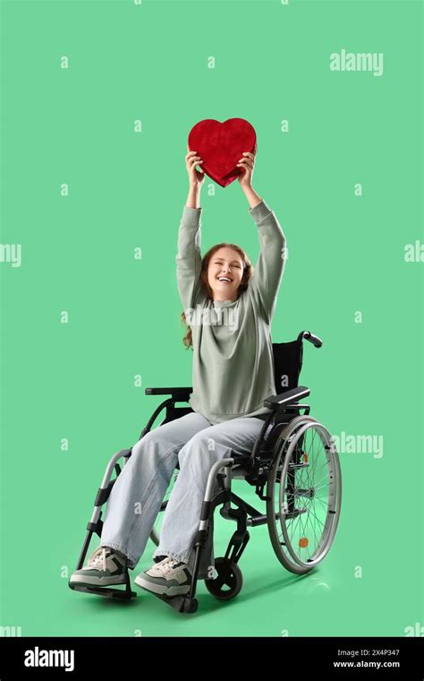 Young Redhead Woman In Wheelchair With Heart Shaped T Box On Green