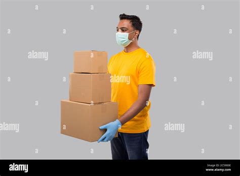 Delivery Man Holding A Lot Carton Boxes Wearing Medical Mask And Gloves Isolated Indian