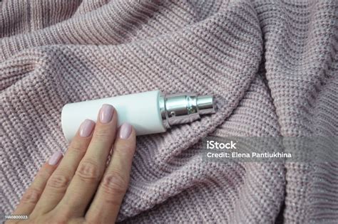 분홍색 니트 스웨터의 배경에 아름 다운 매니큐어와 크림 한 병을 가진 여성 손 겨울 피부 관리 겨울에 대한 스톡 사진 및 기타