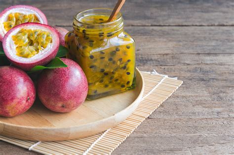 수 제 열정 과일 나무 접시에 병에 잼 열정 과일 나무 테이블 복사 공간 배경에 대 한 측면 보기에서 잼 신선한 열정 과일과 나무 테이블 자연 개념에서 만든 잼 건강한 생활